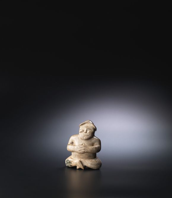 Bonhams : A rare pale brown jade seated male figure Eastern Han Dynasty