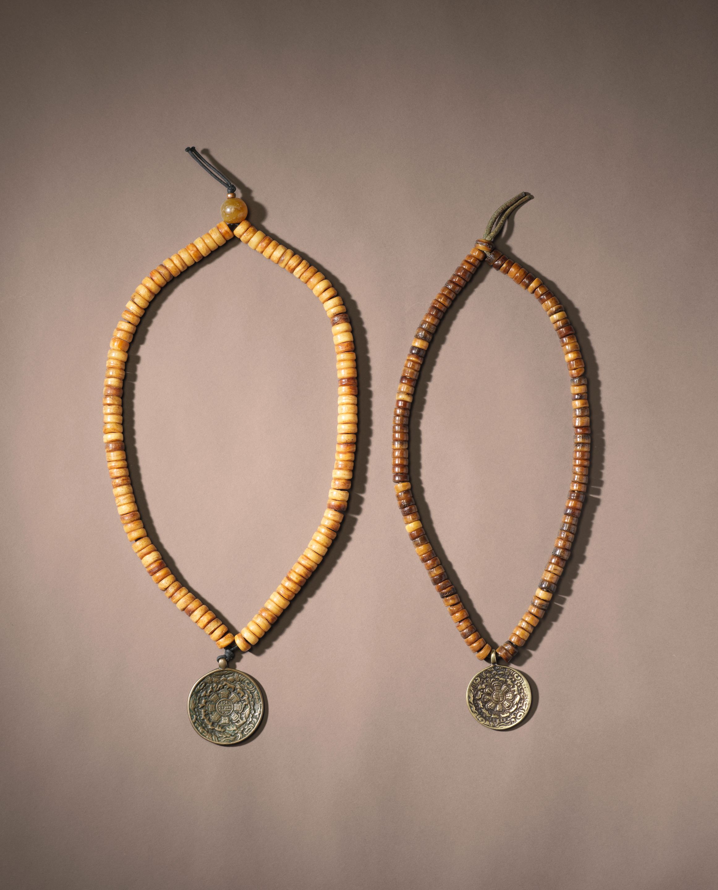 Bonhams : TWO BONE MALAS WITH SIPA-HO AMULETS