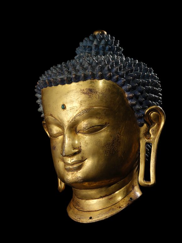 Bonhams : A LARGE GILT COPPER ALLOY HEAD OF BUDDHA NEPAL OR TIBET, 14TH ...